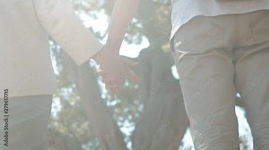Close up of two loving people joining hands, vintage video. Young couple man and woman holding hands, beautiful trees on the background. Summer park, couple trust and happiness concept.