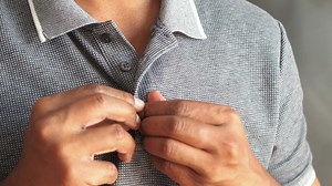 Man buttoning his shirt close up