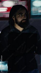 Vertical Video Conceptual representation of cyber crime with male hacker exploiting system vulnerability, using programming technique and surveillance to override digital defenses and leak information