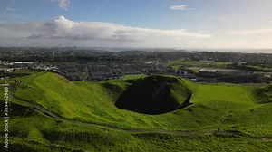Aerial view over Mount Wellington volcano crater, Auckland. Runners and walkers use park and watch city skyline views.