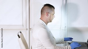 The doctor is typing on the computer keyboard making a diagnosis to the patient. Medical worker in the room diagnosing and urethral x-ray of the lungs. Tuberculosis on x-ray. A doctor in a hospital