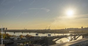 4K UHD timelapse of city life. Sun rays, blue sky, river and bridge over horizont. Traffic jam at summer sunset time. Motorised slider movement