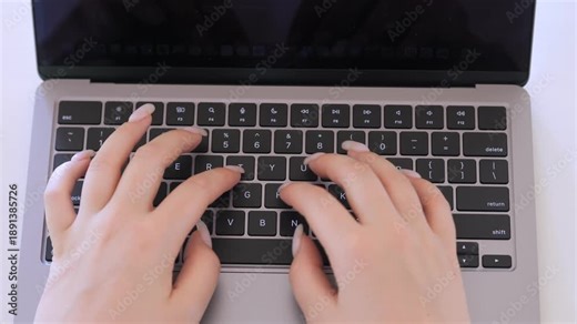 Person is typing on a laptop keyboard. The keyboard has a number pad and a function key