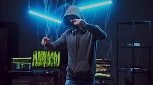 Free stock video - Young guy hacker in a hood listening to the music and dancing in the dark neon room with wires