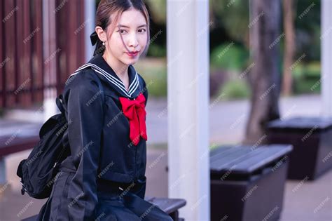 버스 정류장에 앉아 코스프레 일본 교복을 입은 여성 프리미엄 사진