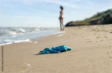 Swimsuit In The Sand On The Beach And Naked Female Figure Stock Photo