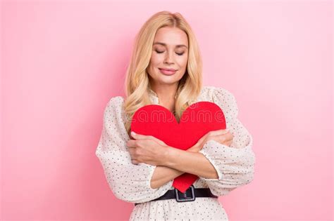 Photo Portrait Of Pretty Blonde Female Embrace Red Heart Card Closed Eyes Dressed Stylish White