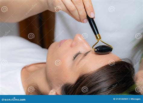 Rejuvenating Effects Of Guasha Facial Massage With A Jade Stone Roller Known For Promoting