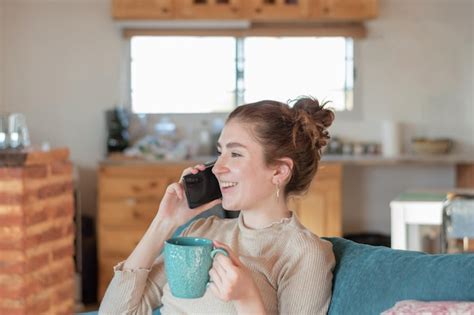 Premium Photo Girl Smiling On The Sofa With Cell Phone And Coffee