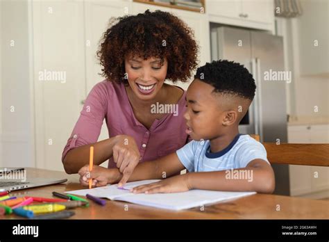 Happy African American Mother And Son Doing Homework At Home Smiling