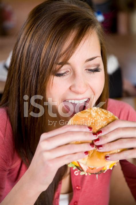 十几岁的女孩吃一个汉堡 库存照片 Freeimages