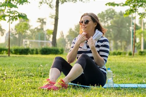 Mujer Madura Descansando Después De Los Ejercicios De Ajuste Sobre Colchoneta En El Parque