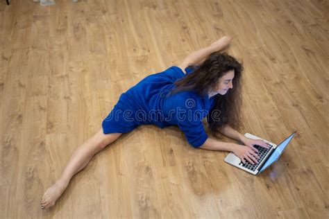 Flexible Woman Exercising At Home In Front Of Her Laptop Stretching Her Legs In The Split
