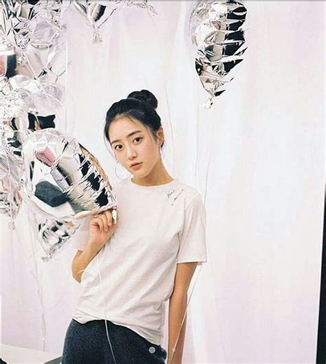 A Woman Holding Up Some Balloons In Front Of Her Face
