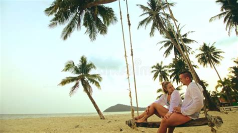 Man On The Swing On Tropical Beach The Guy In White Shirt Enjoy Life And Has Fun Summer